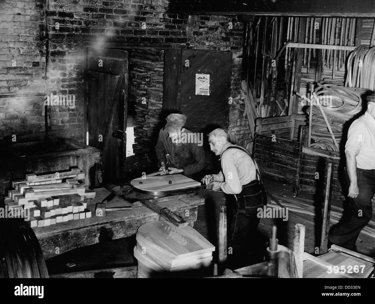 Workers are shown bending chair backs as part of a manufacturing ...
