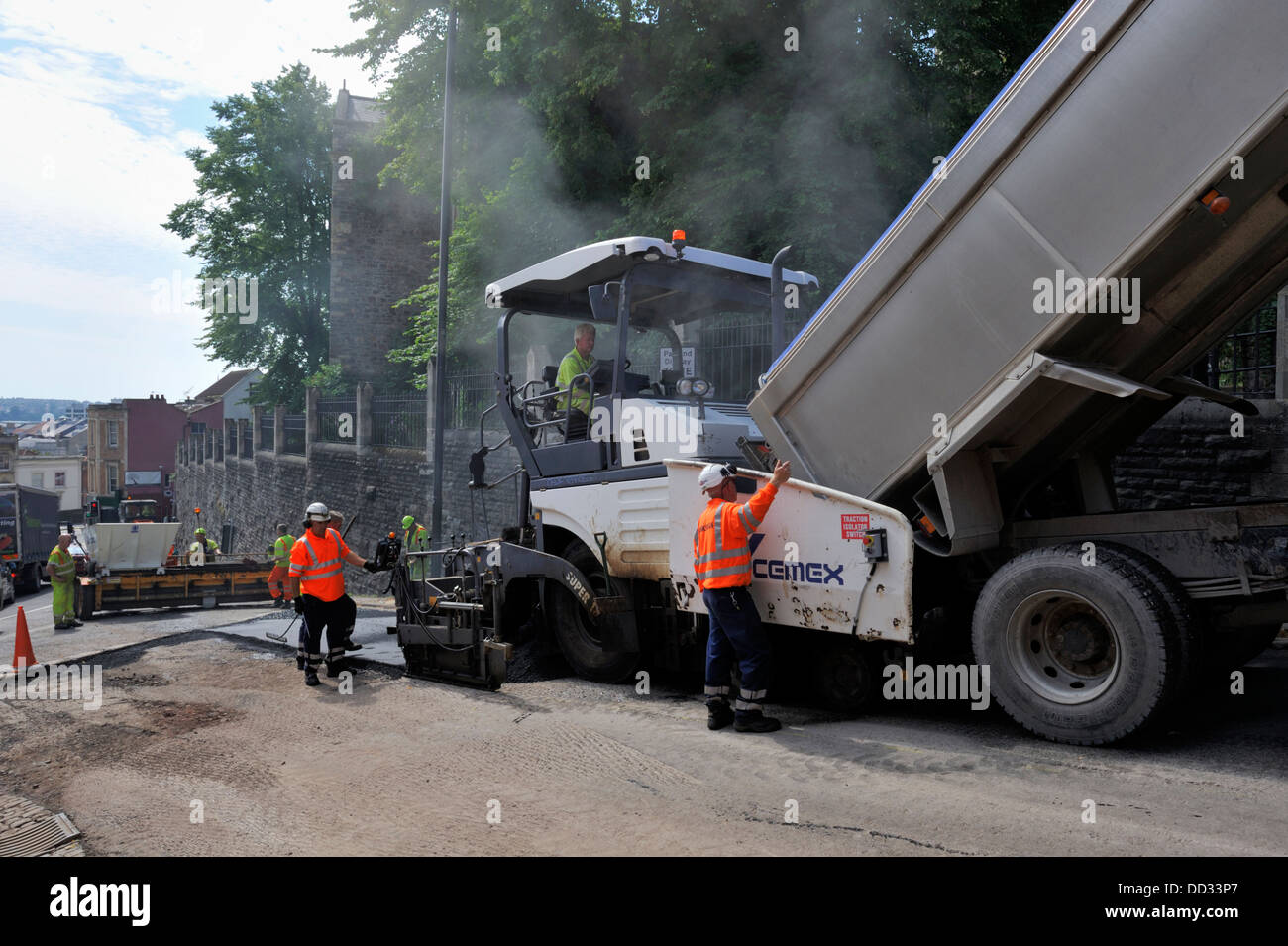 Road works, asphalt spreading machine being loaded with asphalt from ...
