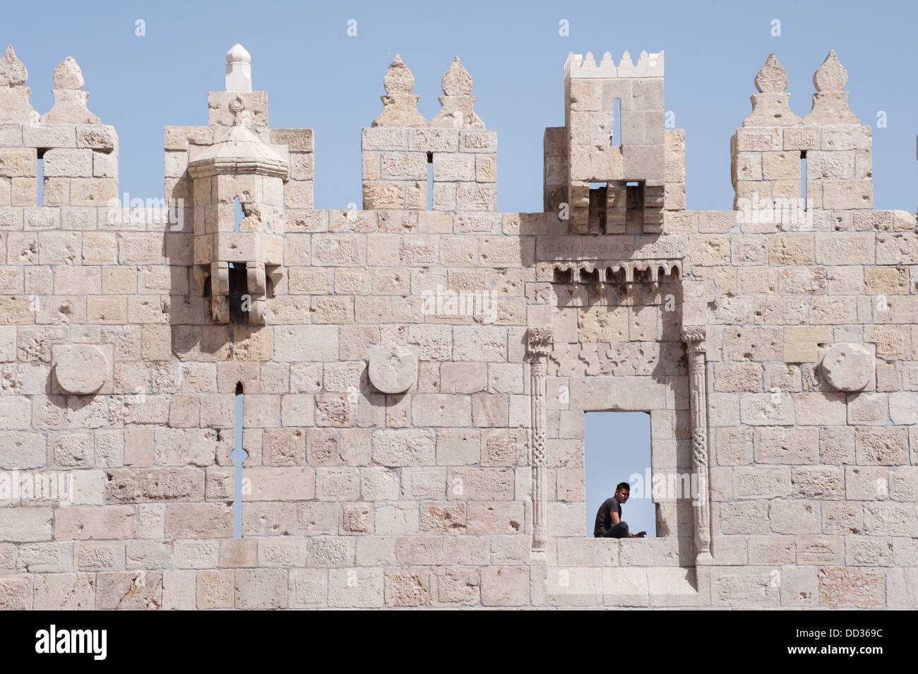 A Palestinian youth sits in a window above the Damascus Gate to the Old ...