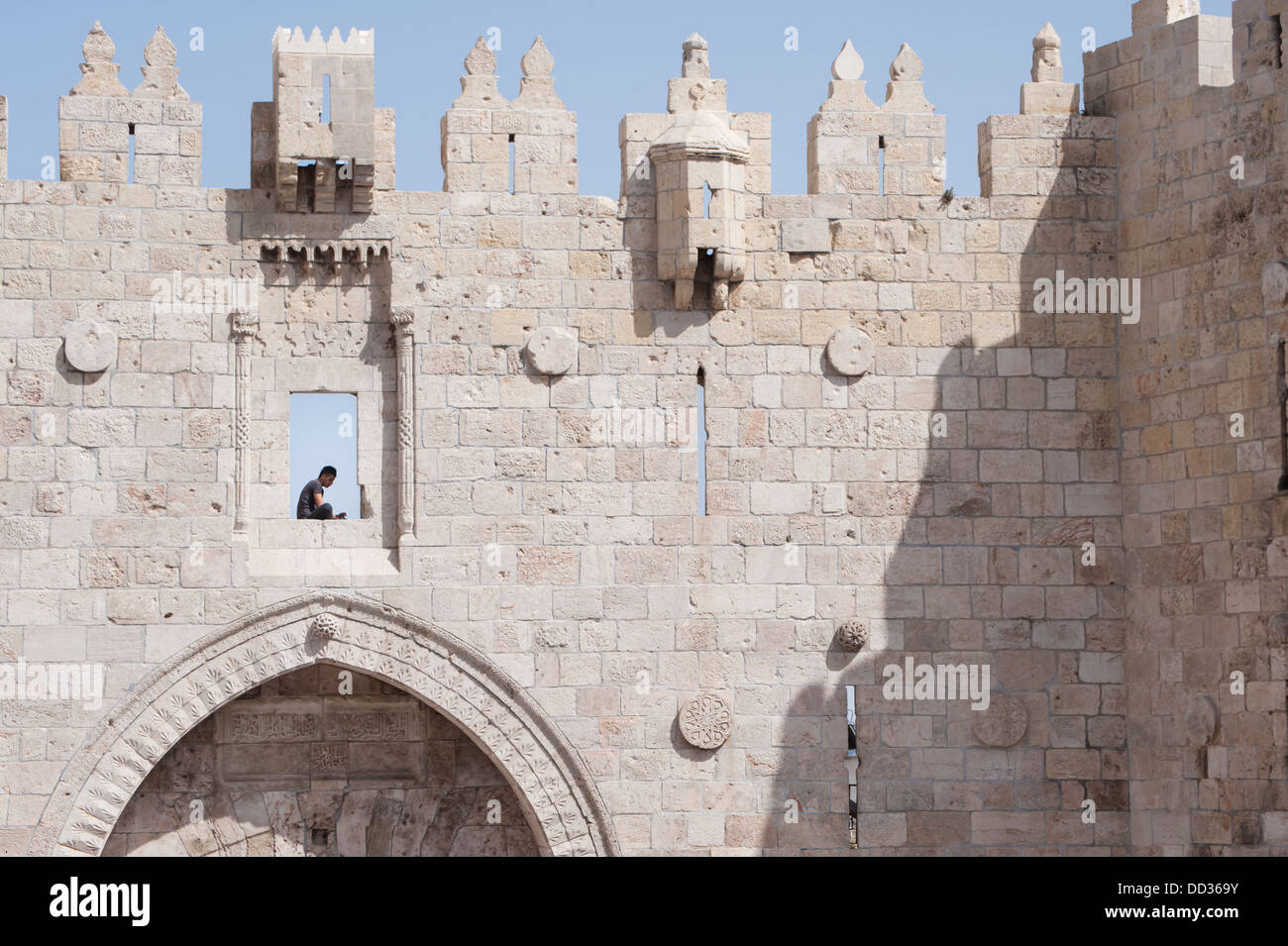 A Palestinian youth sits in a window above the Damascus Gate to the Old ...