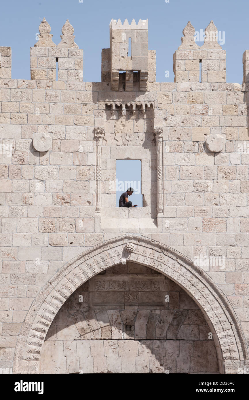 A Palestinian youth sits in a window above the Damascus Gate to the Old ...