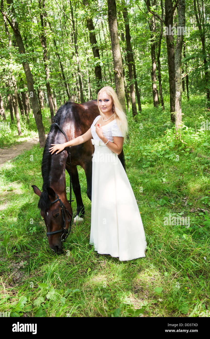 Beautiful bride and a horse in the forest Stock Photo - Alamy