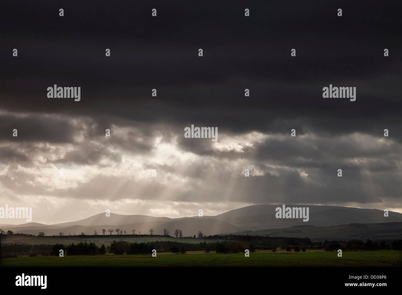 Rays Of Sunlight Shining On The Hills Through Dark Storm Clouds ...