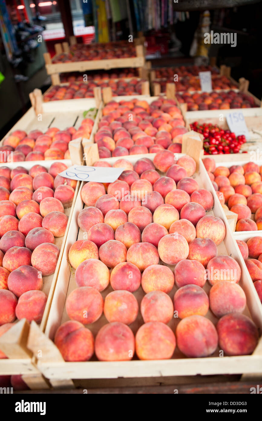 Closeup of fresh peaches in crates on sale at public weekend produce ...