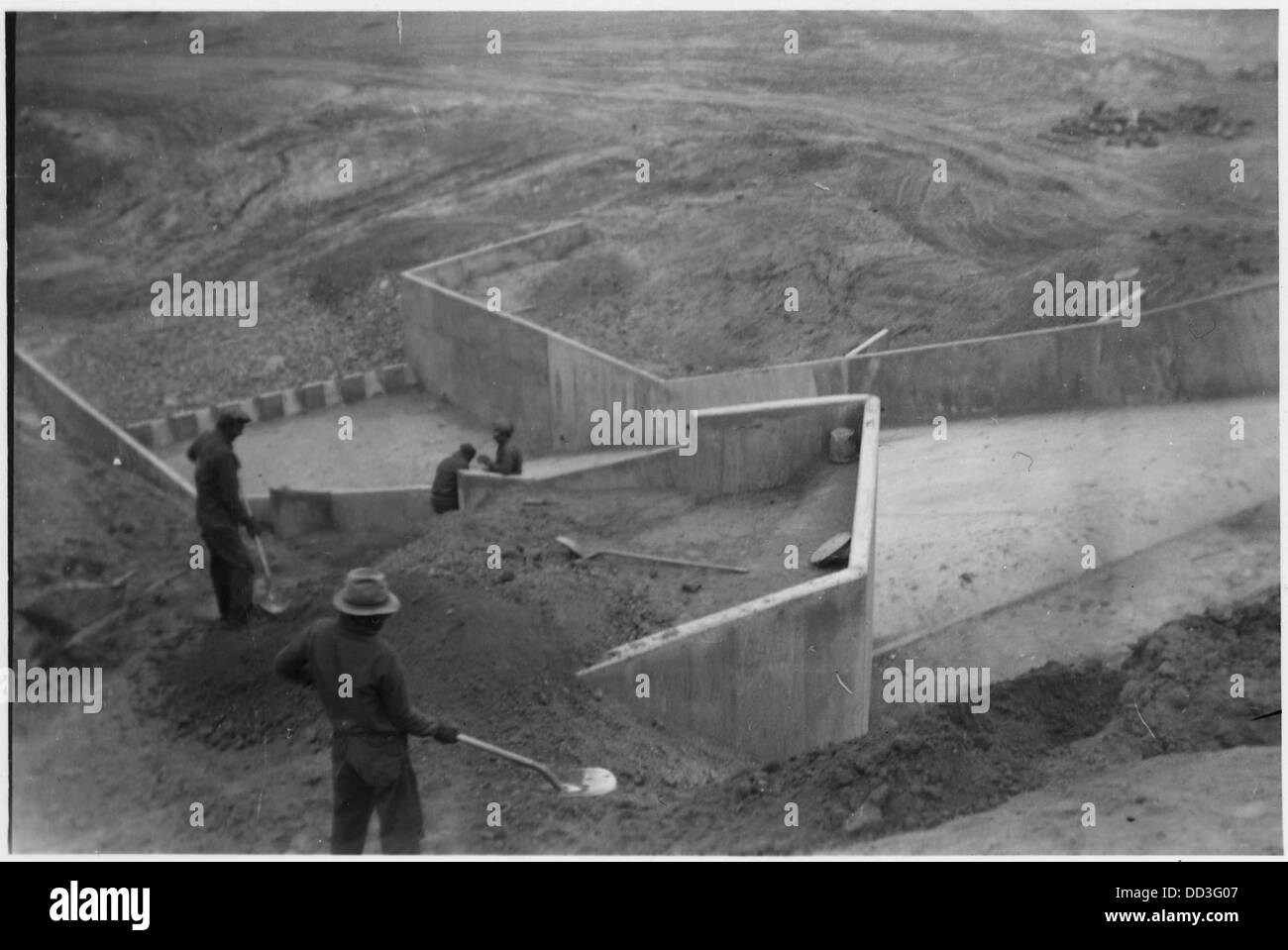 This photograph depicts the construction of a spillway, a vital part of ...