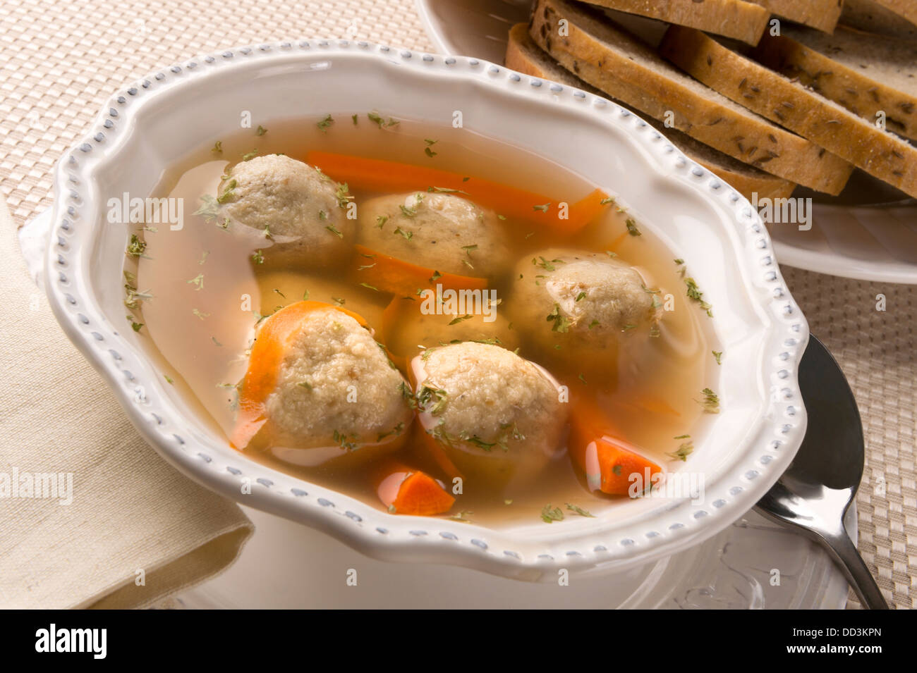 Traditional Jewish passover dish matzah ball soup served with rye bread ...