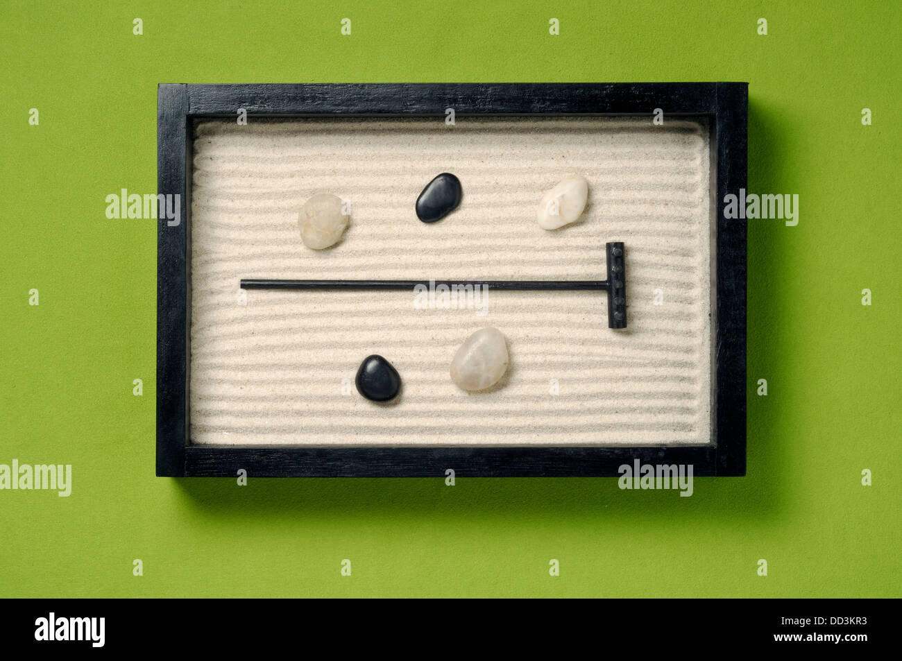 A small rectangular sand zen garden with rocks and a small rake Stock ...
