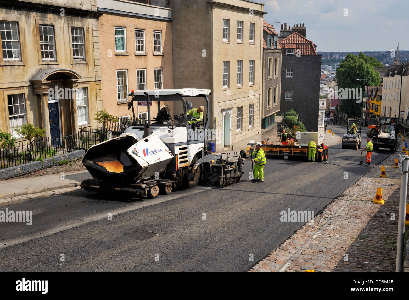 Road works resurfacing street with specialized asphalt spreading ...
