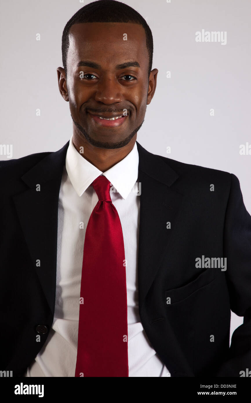 Handsome black man in a suit and red tie, looking at the camera with a ...