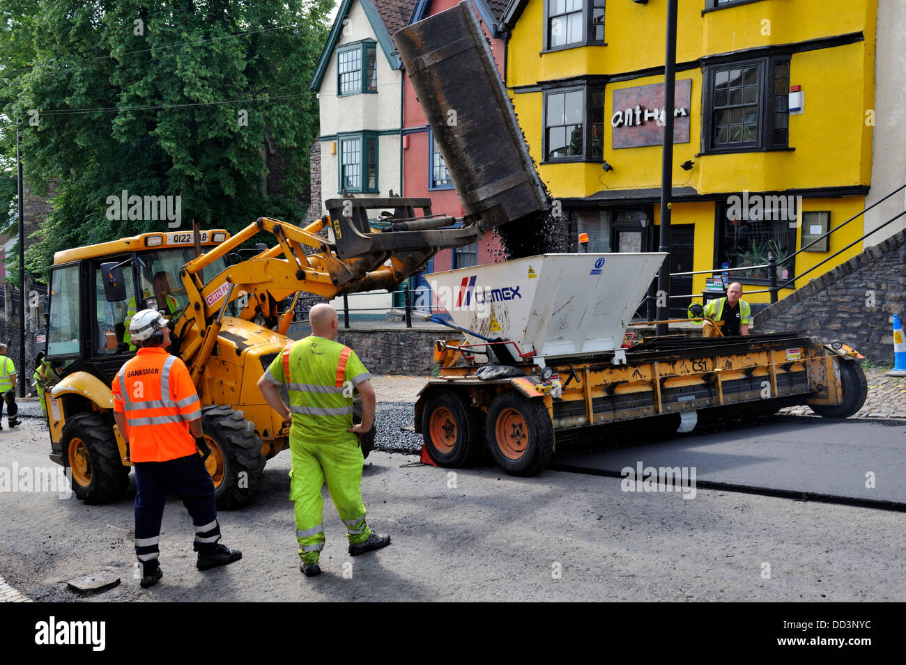 Front-end loader filling asphalt spreading machine for road resurfacing ...