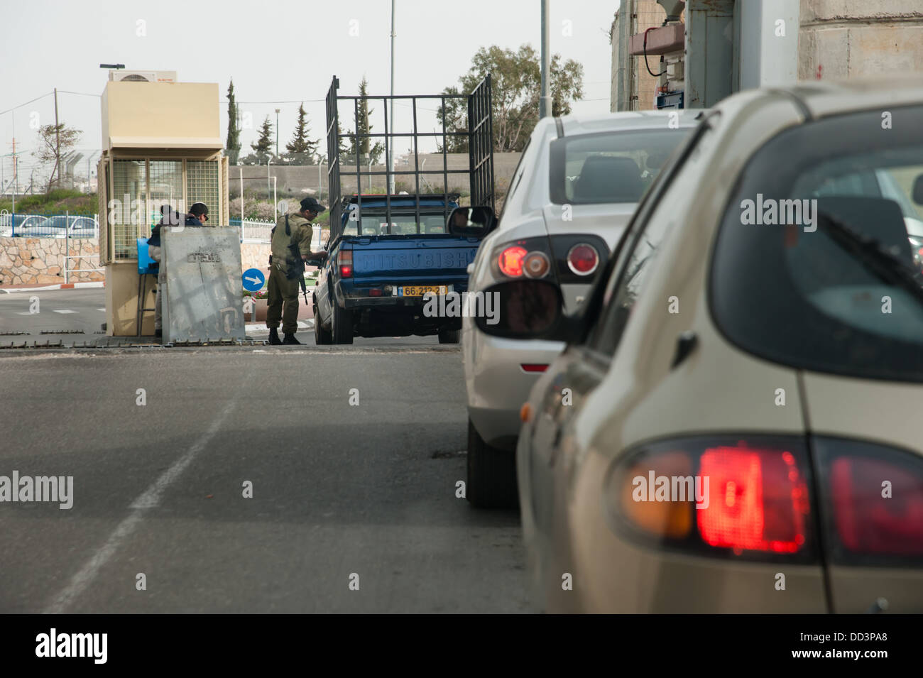 A soldier checks cars passing through the Israeli military checkpoint ...