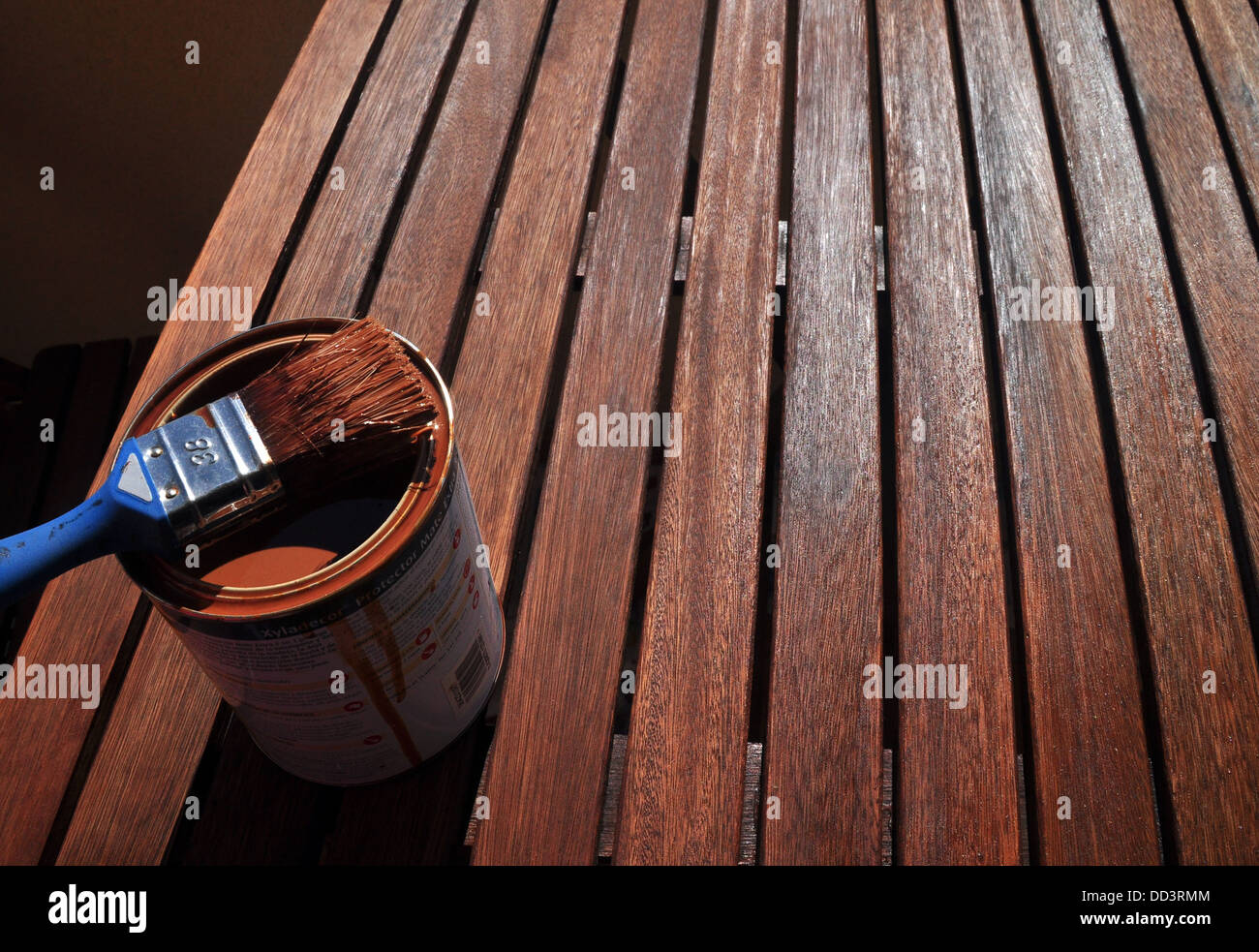 Can of varnish and brush ready for paint a garden table (I Stock Photo ...