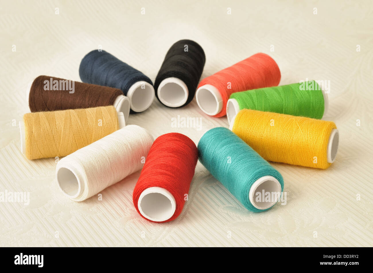 Spools of threads of different colors on light table cloth Stock Photo ...