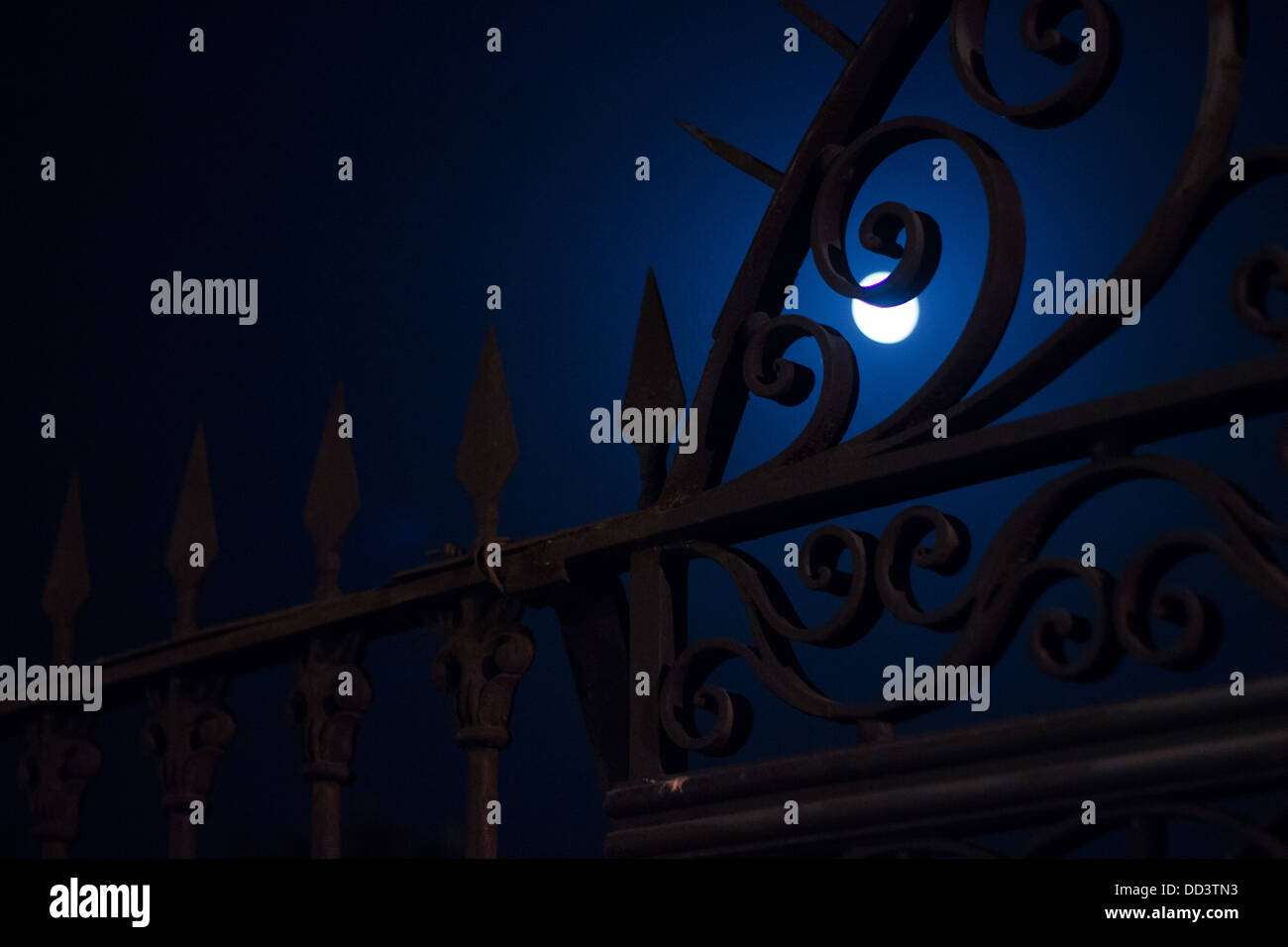 Moon rising behind an metallic fence Stock Photo - Alamy