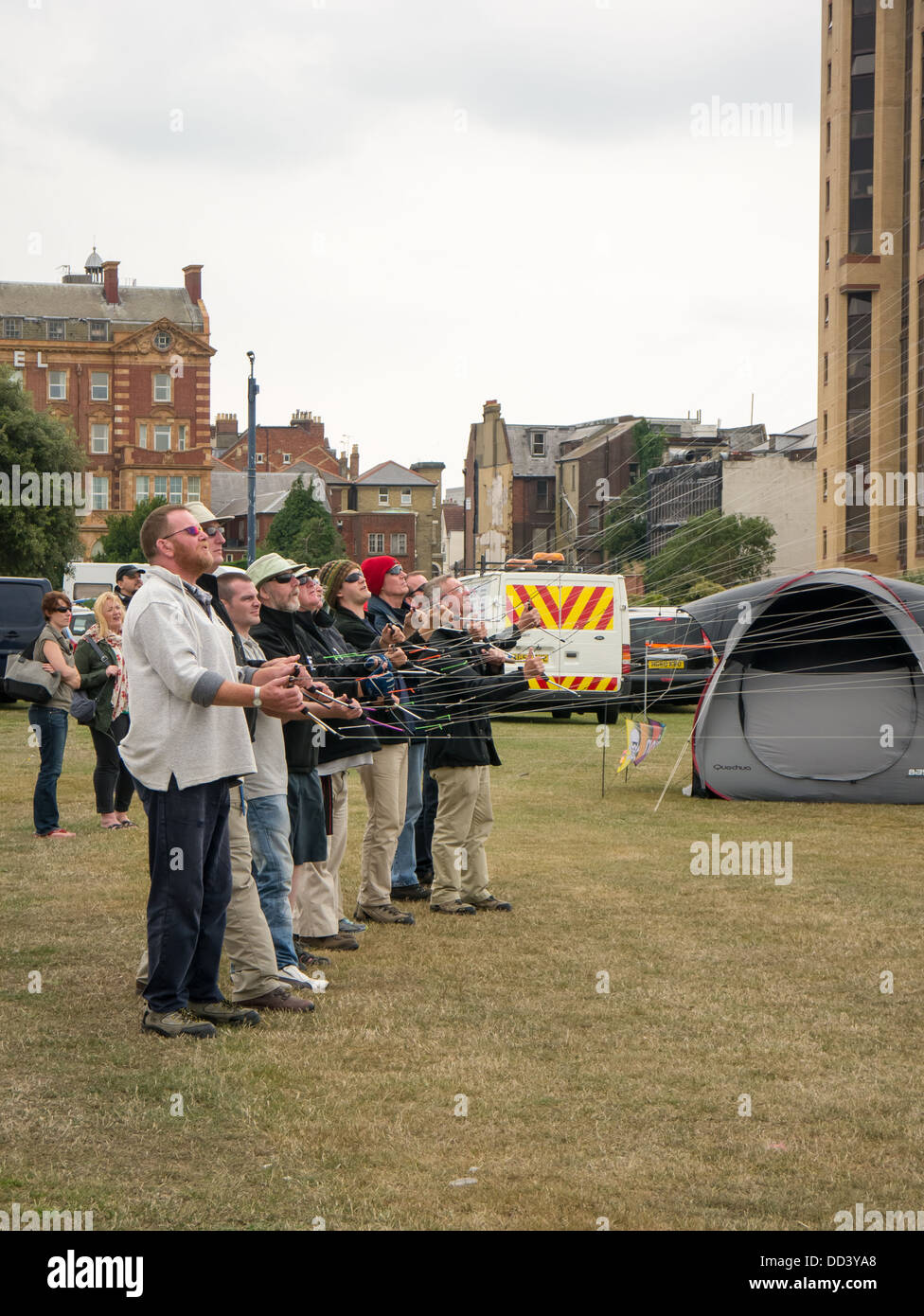 Members of a co-ordinated kite display team stand in line holding the ...