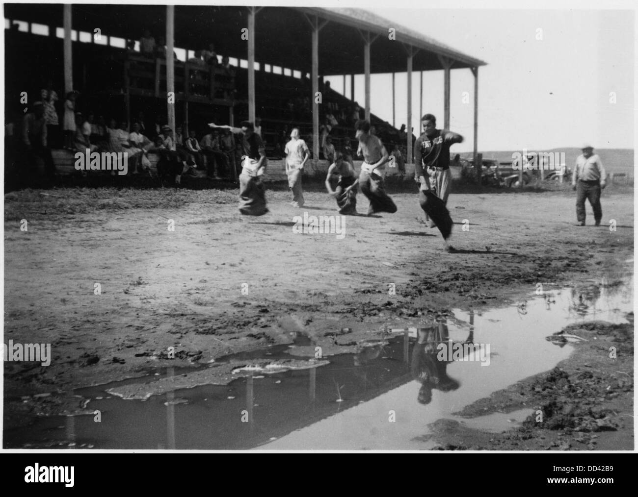 Participants compete in a sack race shortly after rainfall, with wet ...