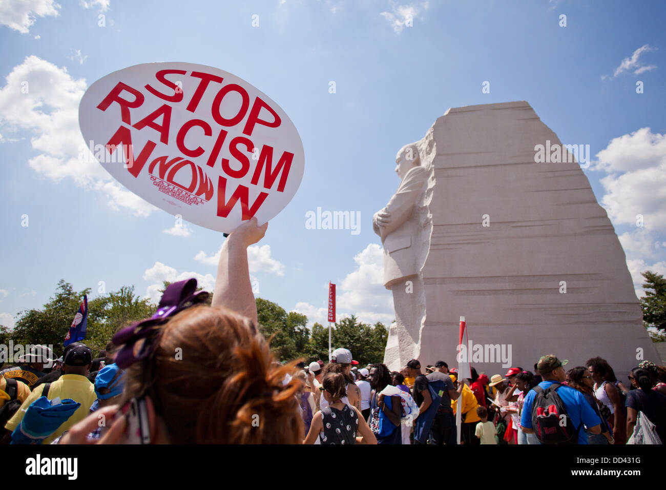 Woman holding up "Stop Racism Now" sign at the MLK memorial ...
