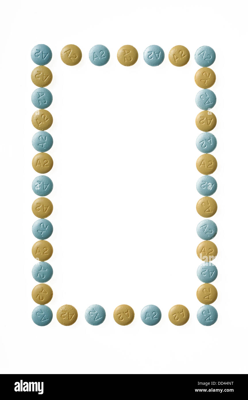 A tight rectangular shape of blue and green medicine pills on a white ...