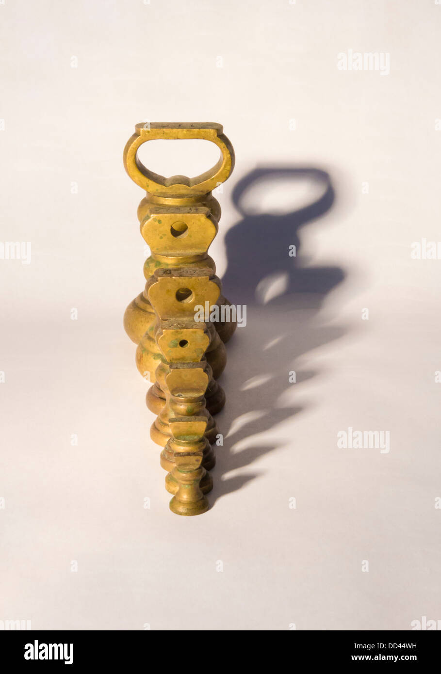 Brass Kitchen weights lined-up on white background casting shadow Stock ...