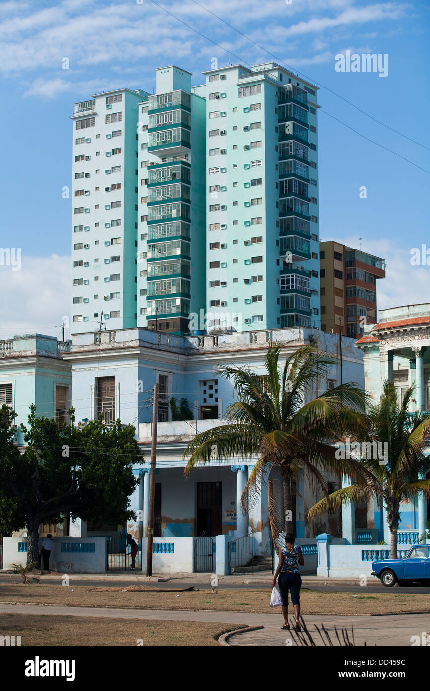 The contrast of an old Havana house and a tower block, both painted ...