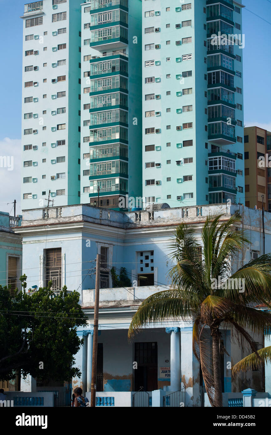 The contrast of an old Havana house and a tower block, both painted ...