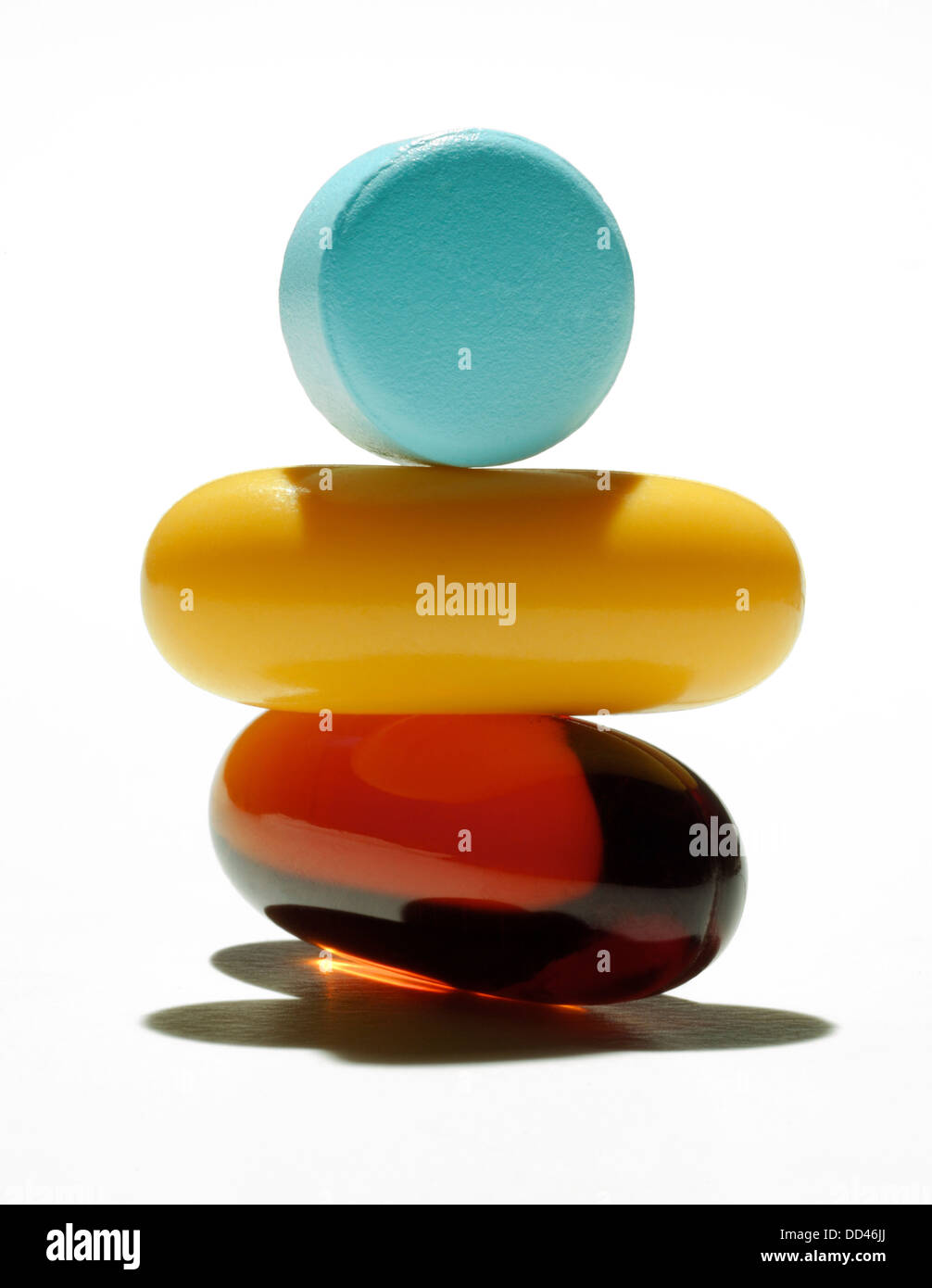 A balance stack of a vitamin capsule, pill and tablet. White background ...