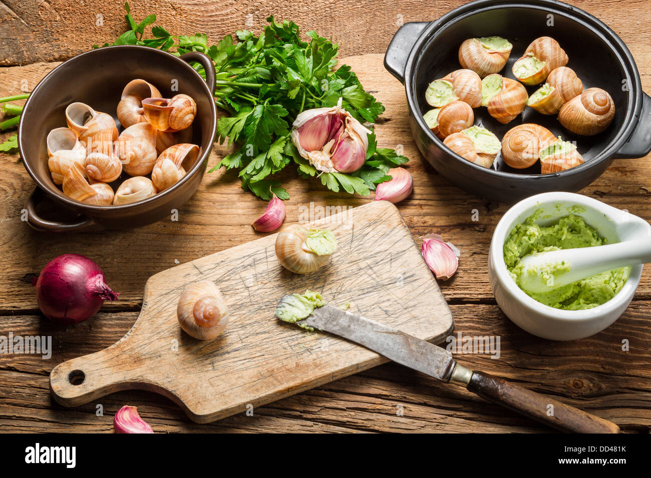Preparing snails with garlic butter and herbs Stock Photo - Alamy