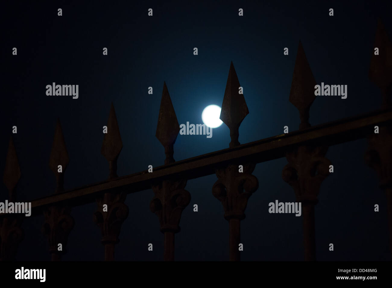 Moon rising behind an metallic fence Stock Photo - Alamy