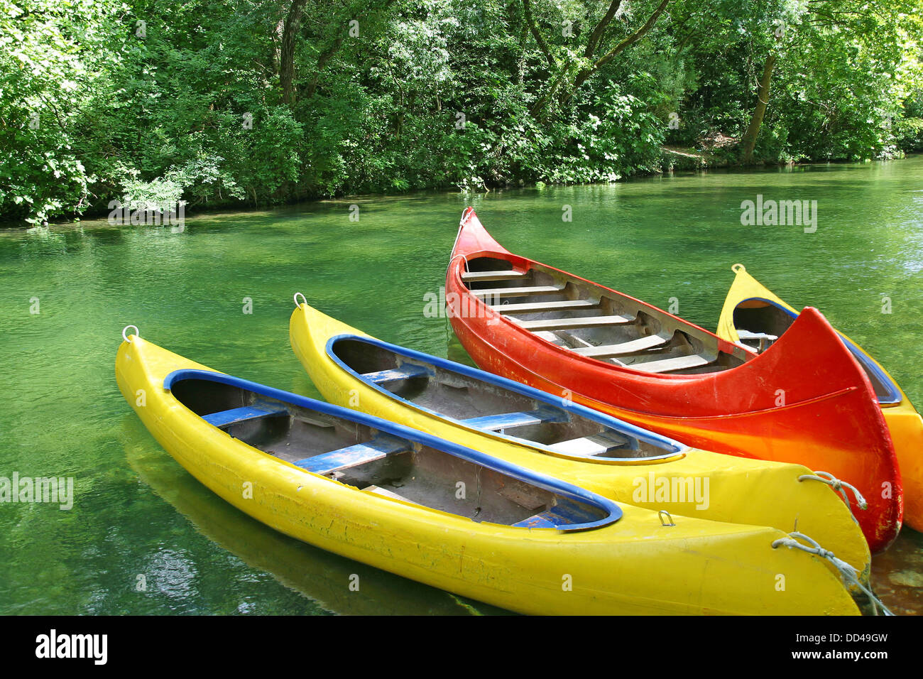 Yellow and red empty plastic canoes in turquoise green river Stock ...