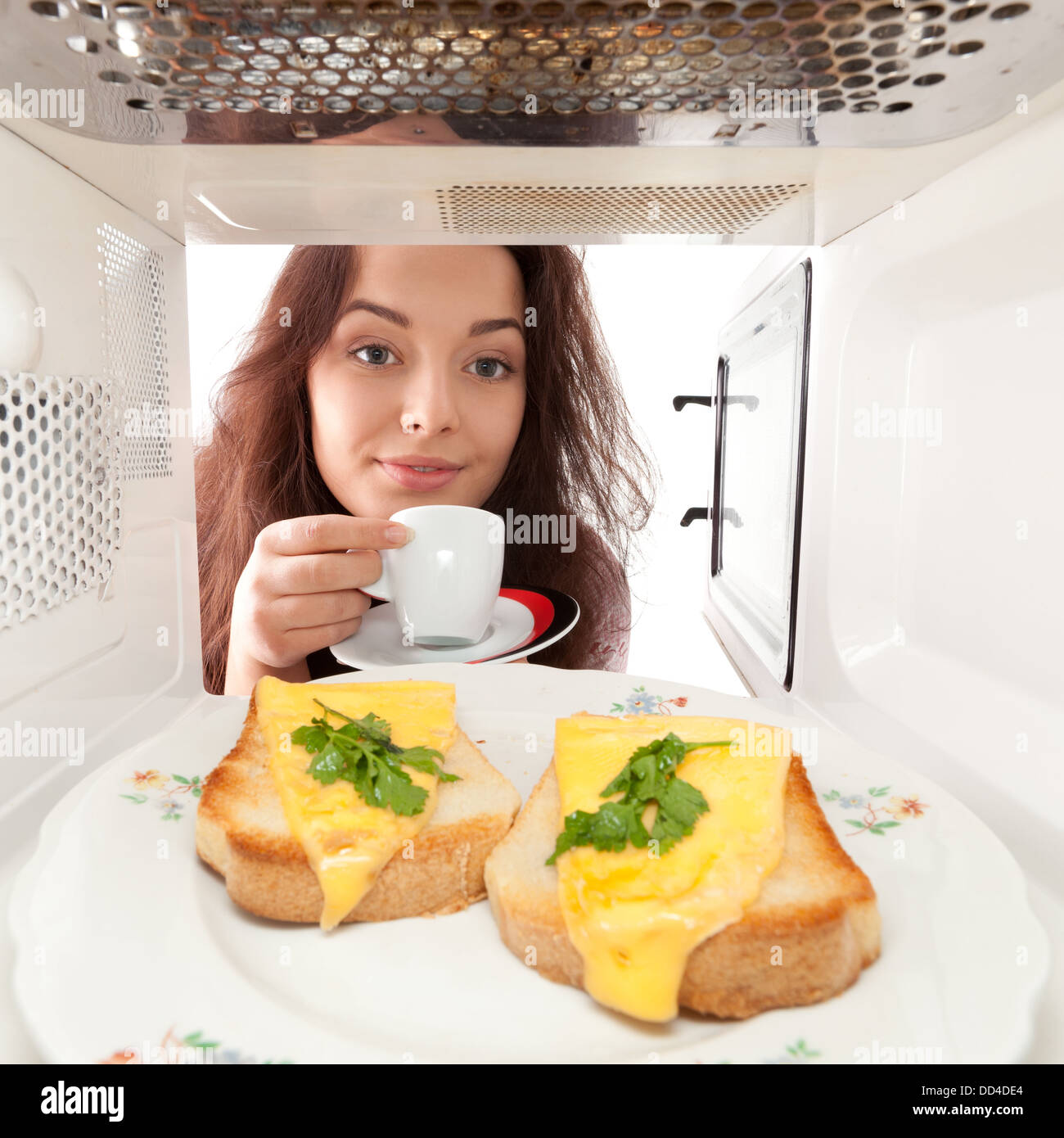 Attractive girl looks in a microwave Stock Photo - Alamy