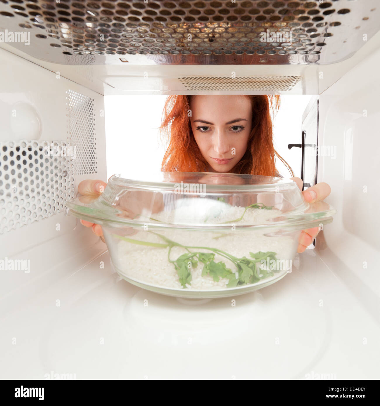 A girl prepares rice in the microwave Stock Photo - Alamy