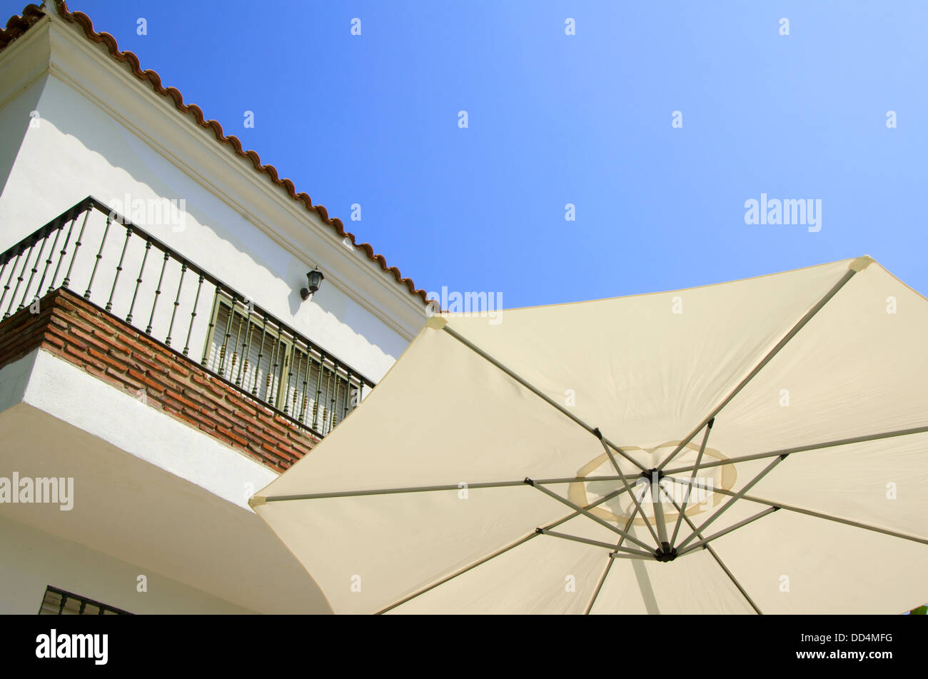 Spanish white house with parasol against a blue sky. Andalusia, Spain ...