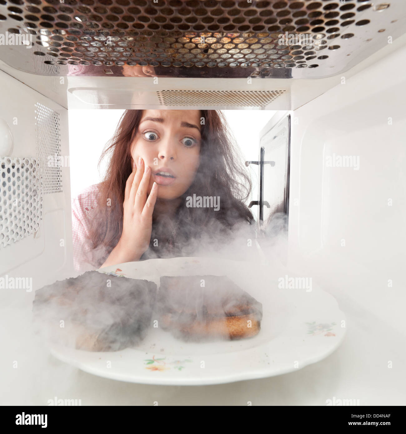 Young girl burn toasts in a microwave Stock Photo - Alamy