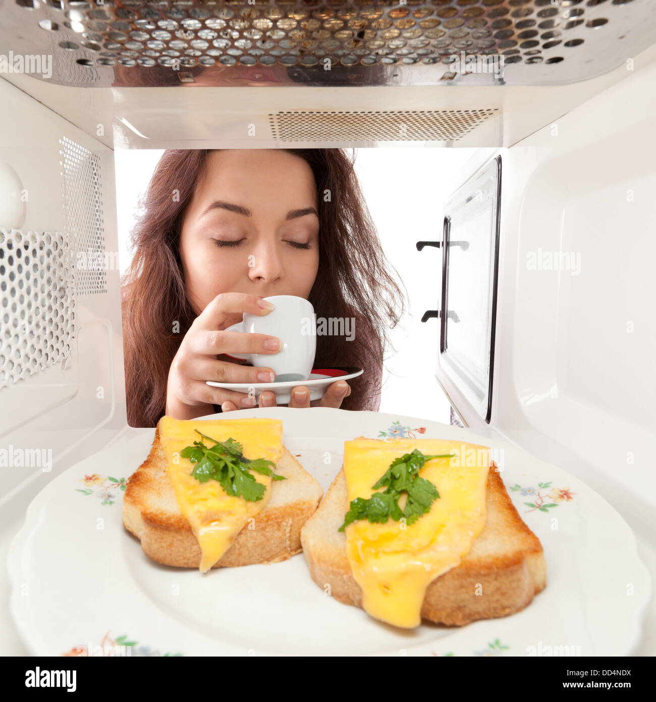 Attractive girl looks in a microwave Stock Photo - Alamy