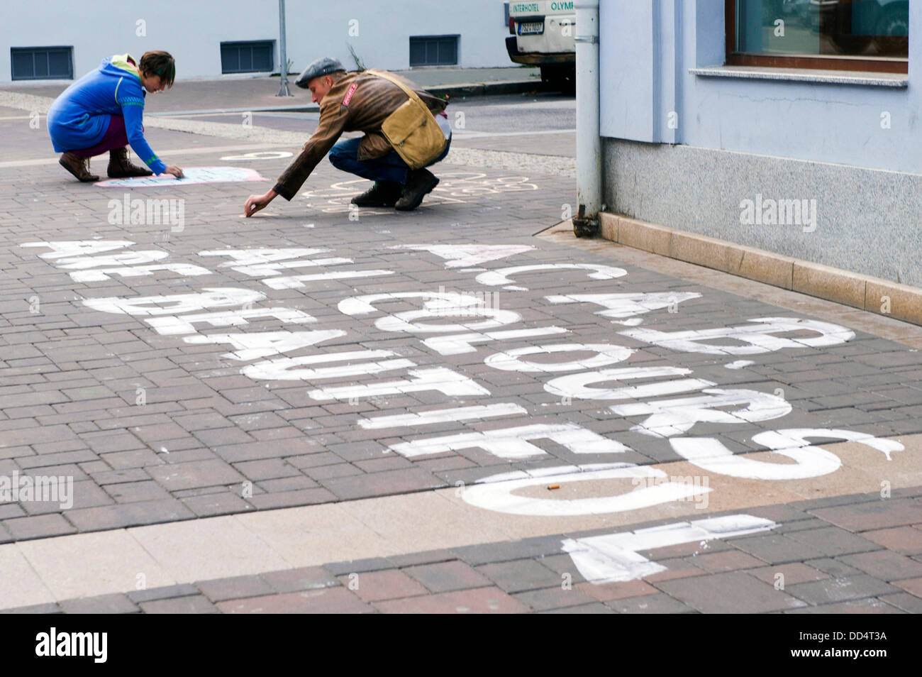 Activists write anti racist slogans to protest on the street against ...