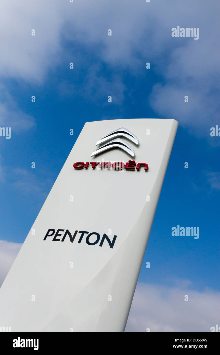 Looking up at Citroen car dealer sign with logo with blue sky and white ...