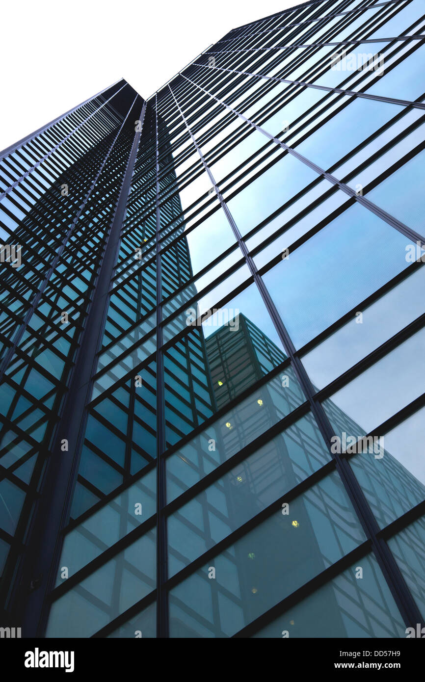 blue building with glass facade with reflections of sky and ...