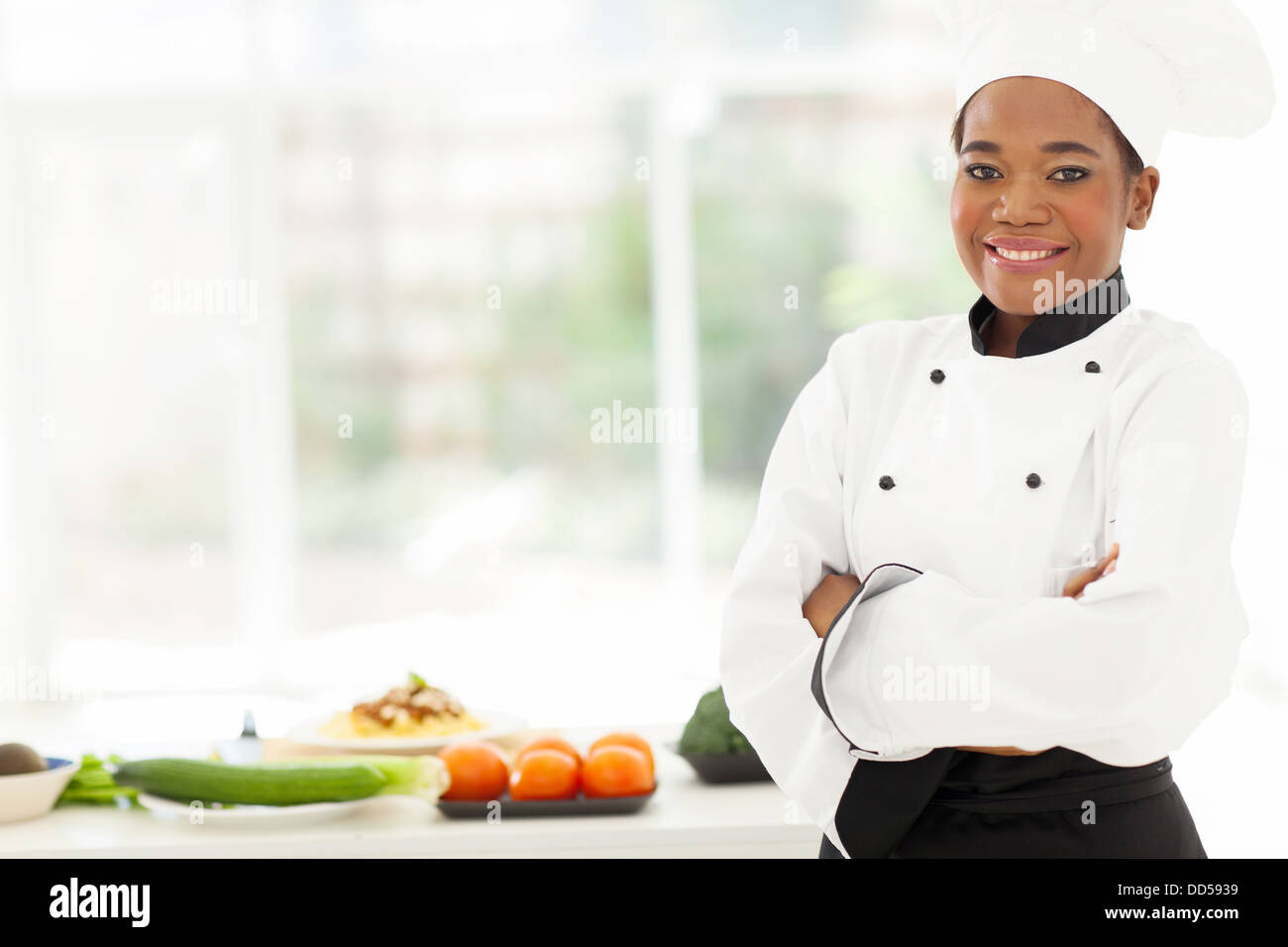 attractive African American female chef with arms folded in restaurant ...