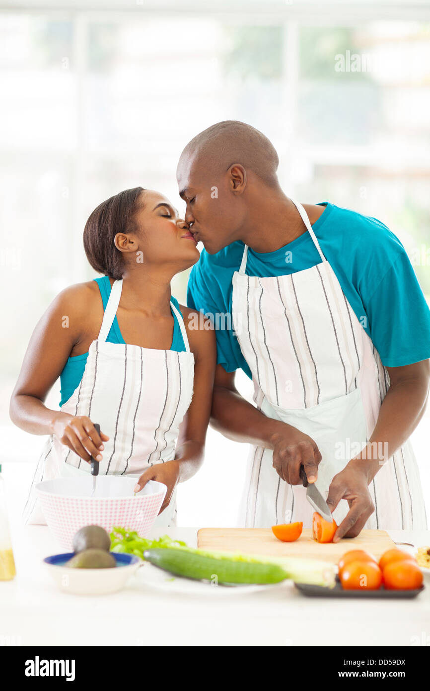 cute African couple kissing in kitchen while cooking Stock Photo - Alamy