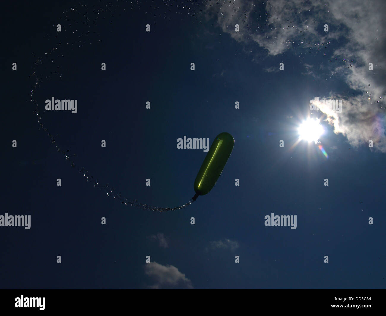 Flying green water balloon Stock Photo - Alamy