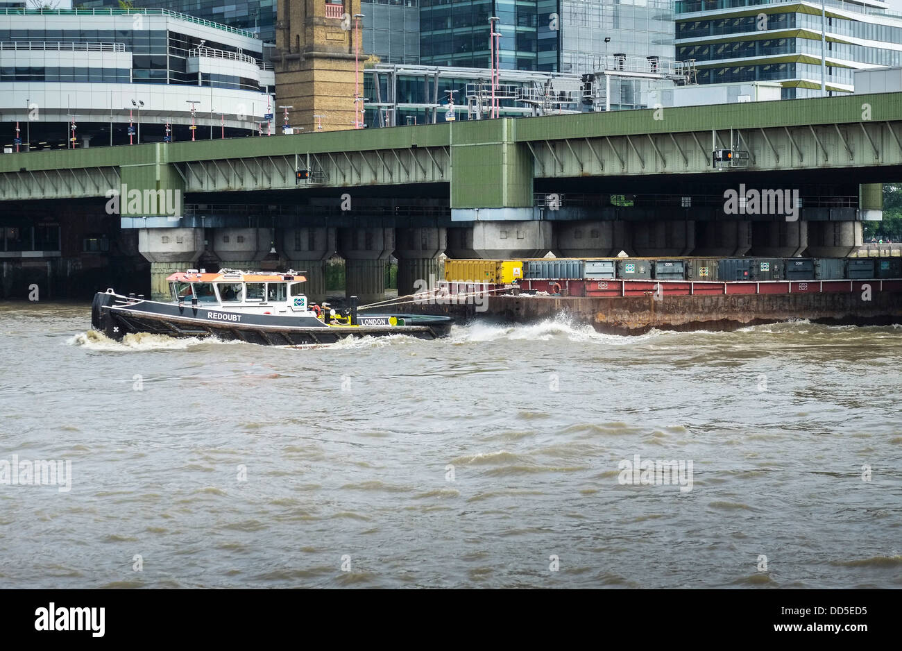 The tug Redoubt towing barges under Cannon Street Railway Bridge Stock ...