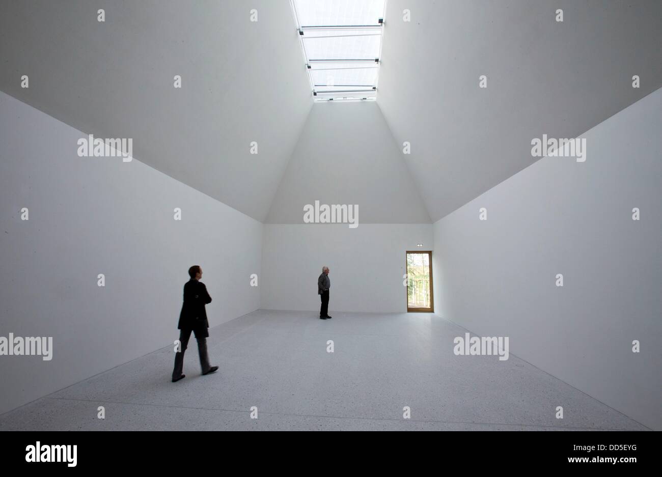 People walk through an empty exhibition hall of the art museum is ...