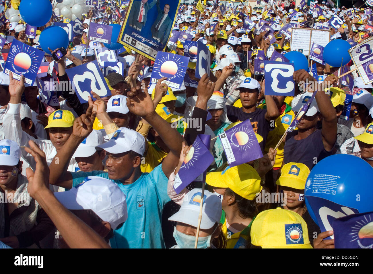 People with signs and banners are cheering at an election campaign ...