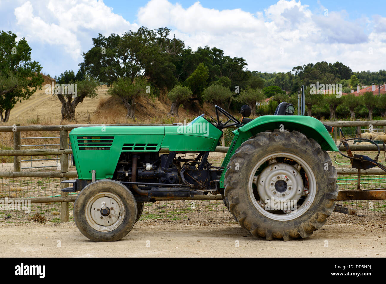 Green tractor in the farm with a cloudy sky Stock Photo - Alamy