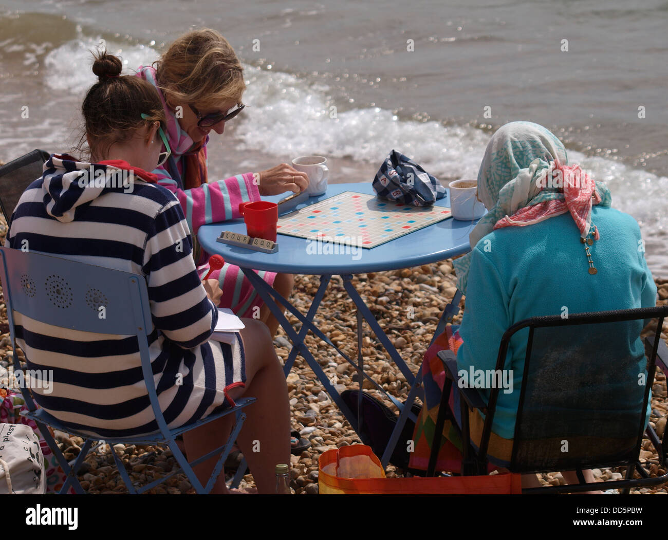 Three women playing Scrabble at the beach, Milford on sea, Dorset, UK ...