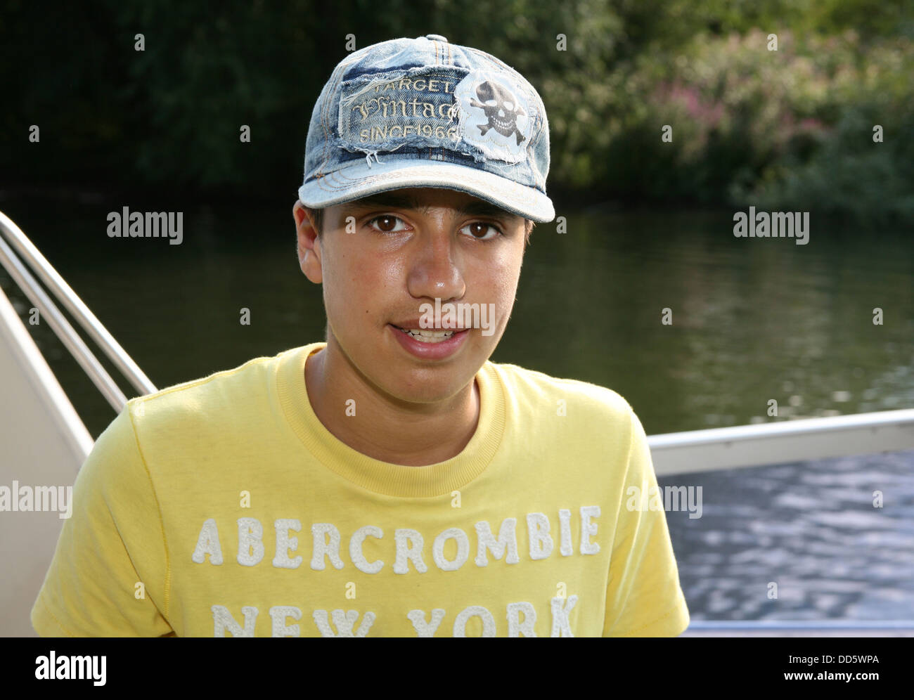 Portrait of smiling brunette boy in baseball cap on boat Stock Photo ...