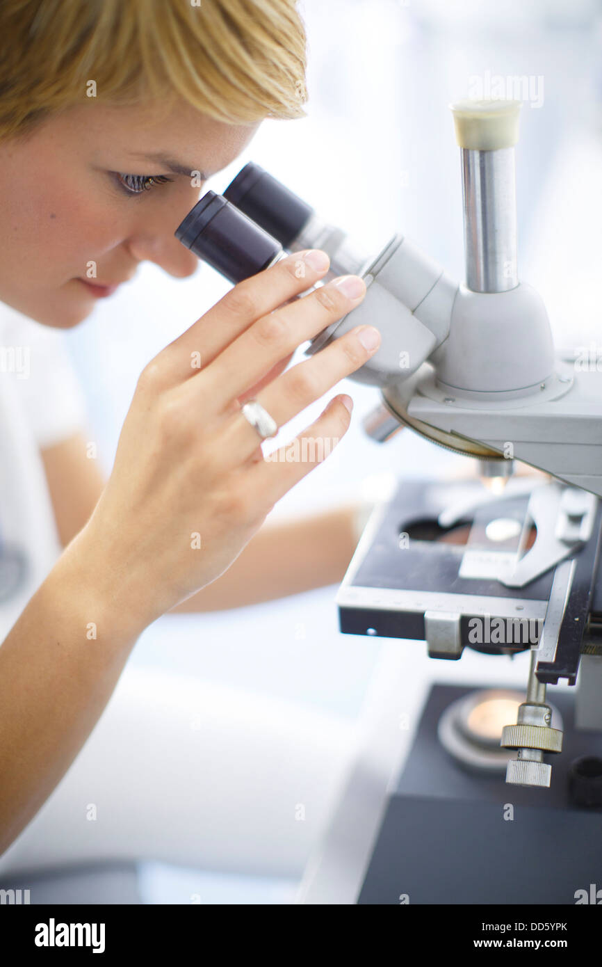 Female Scientist looks through a microscope Stock Photo - Alamy