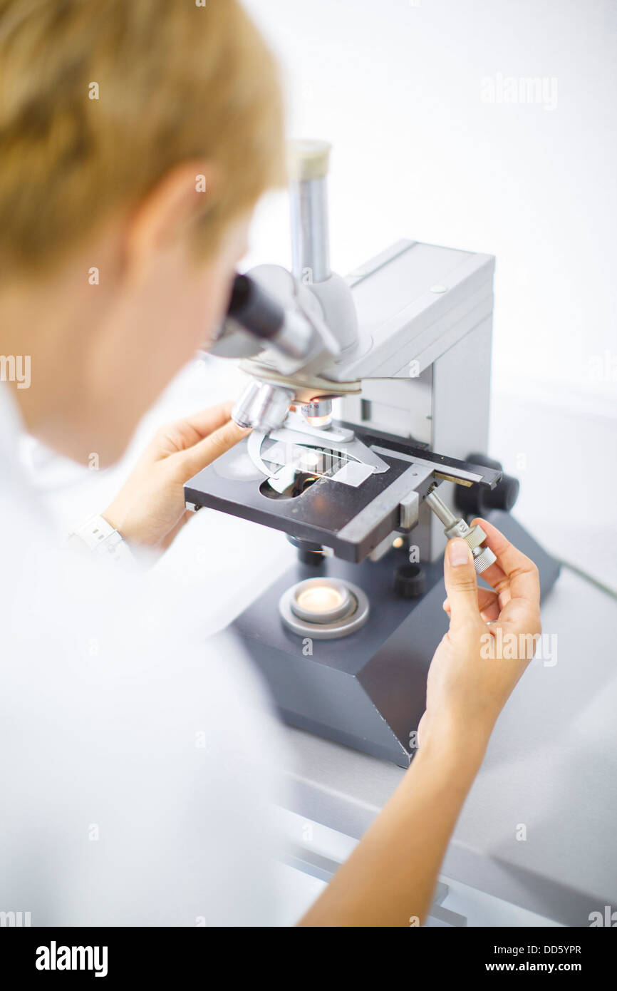 Female Scientist looks through a microscope Stock Photo - Alamy