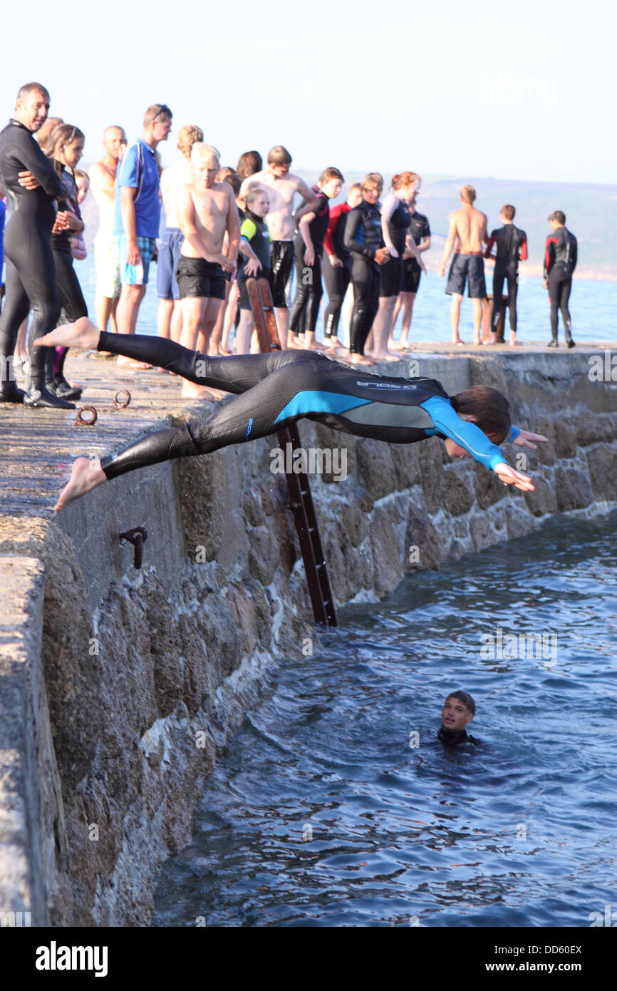 Sennen Cove Cornwall holidaymakers diving into the sea from the harbour ...