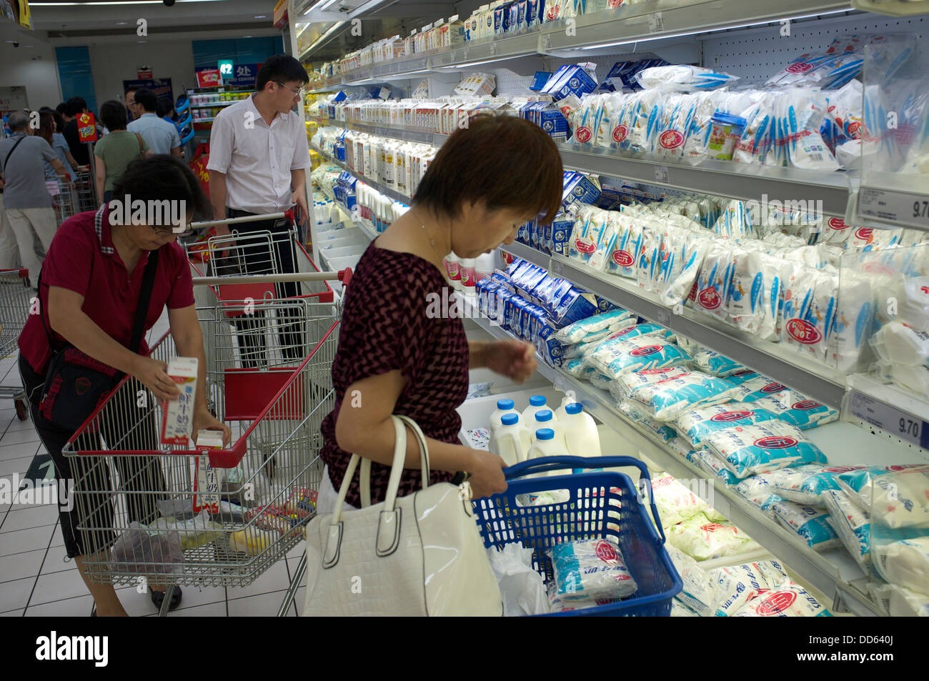 Chinese customers buying milk products in a supermarket in Beijing ...